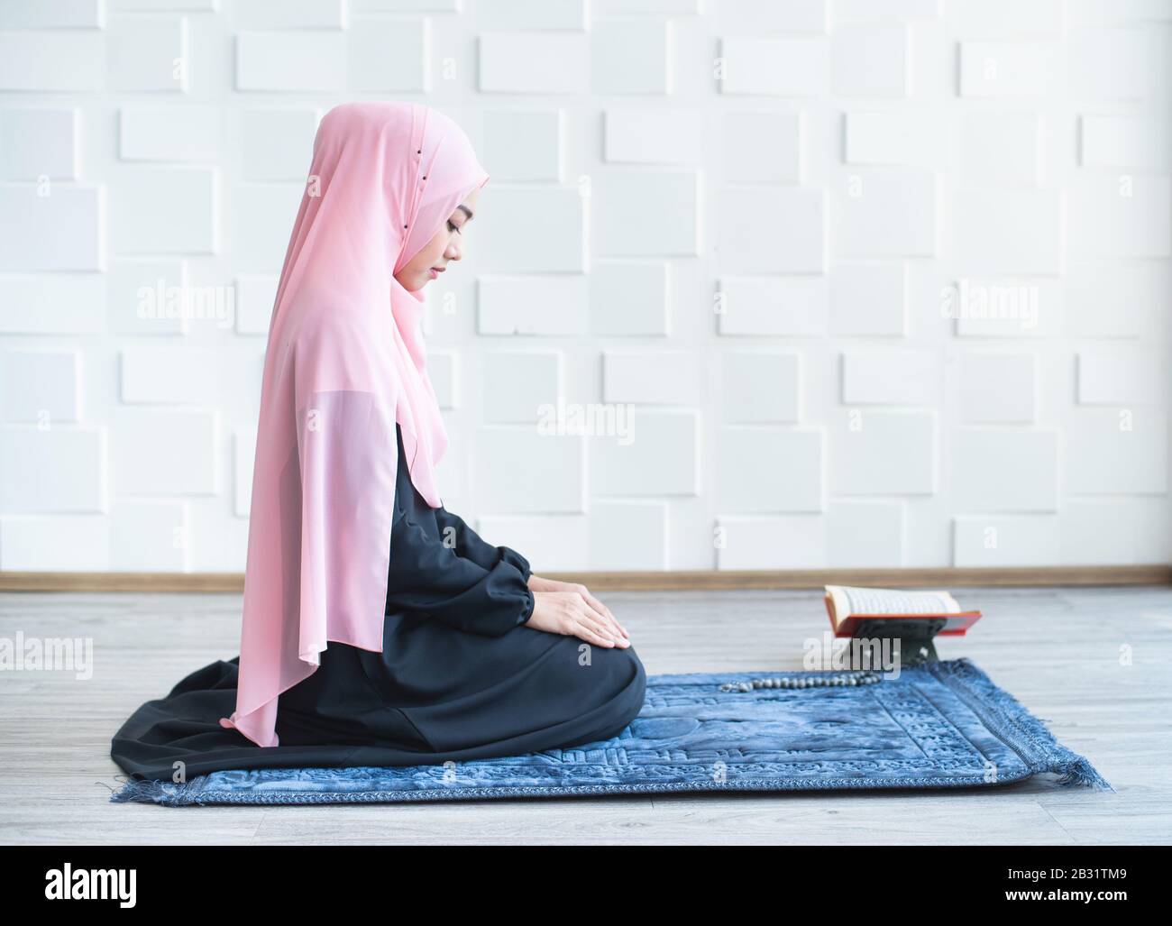 side view of asian beautiful young muslim student woman prayer in hijab ...