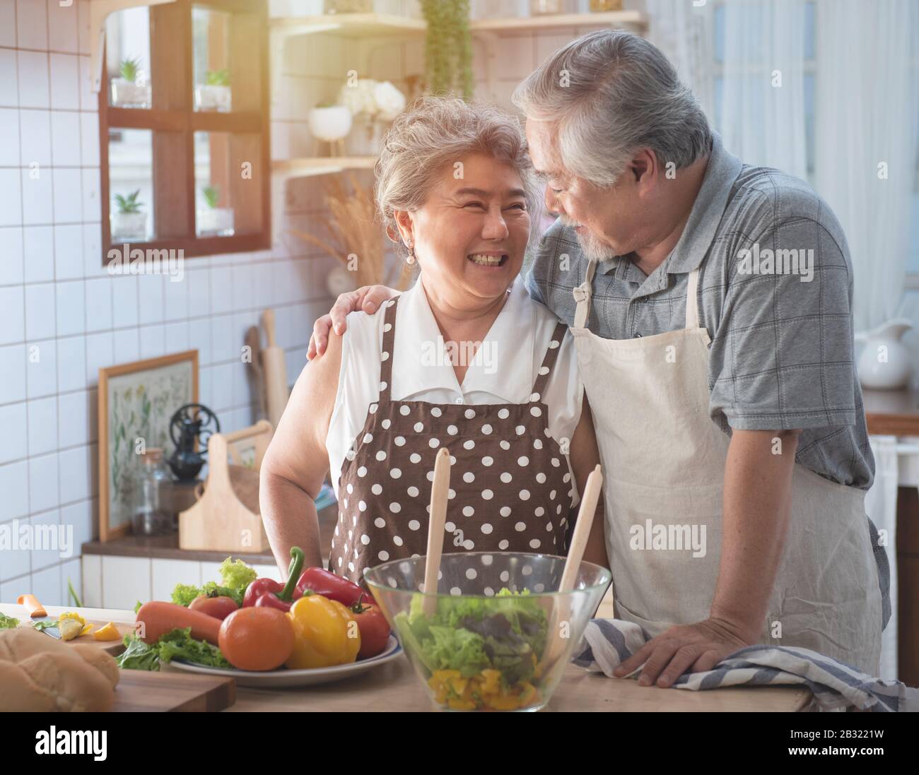 Senior couple having fun in kitchen with healthy food - Retired people ...