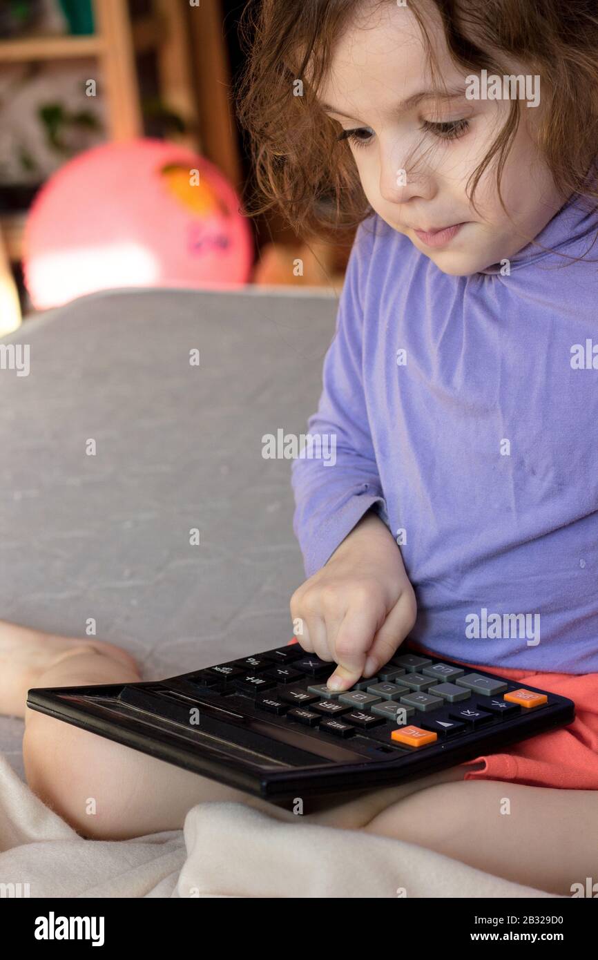 Little kid girl with a calculator in hands Stock Photo - Alamy