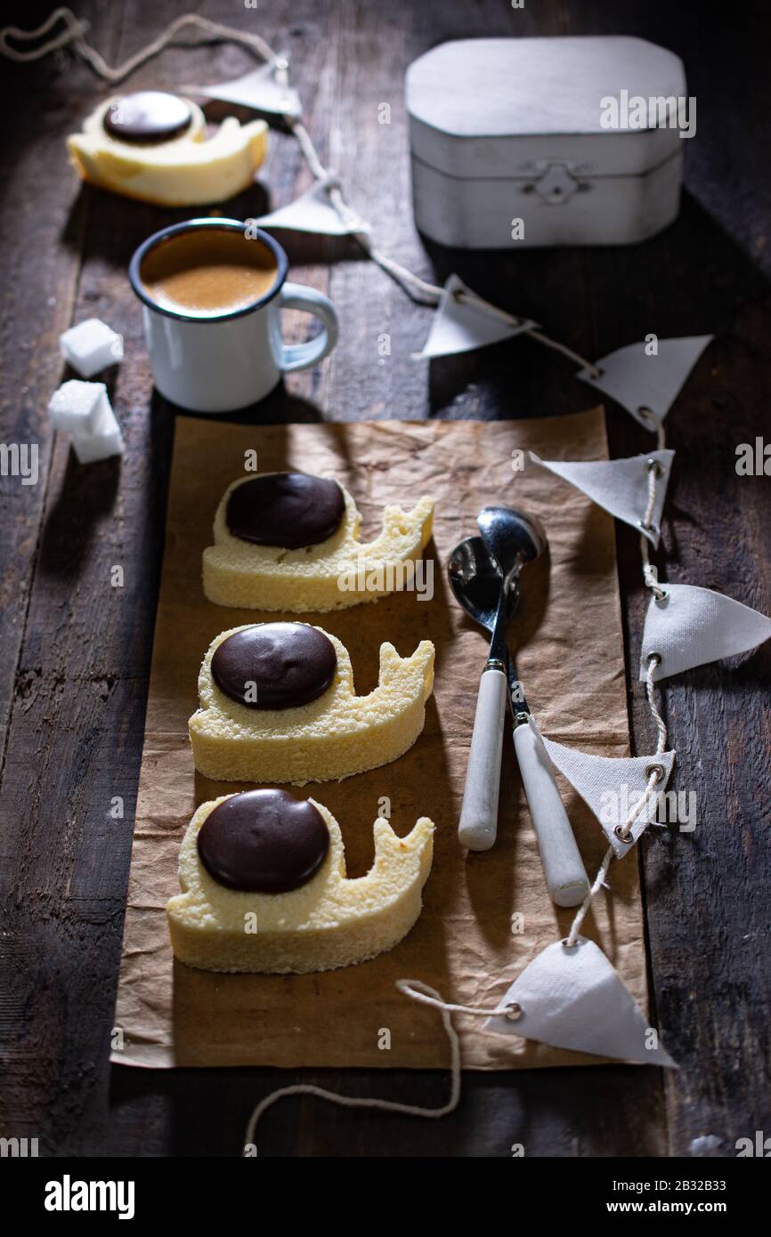 Snail shaped cookies coated in chocolate . Dessert with biscuits ...