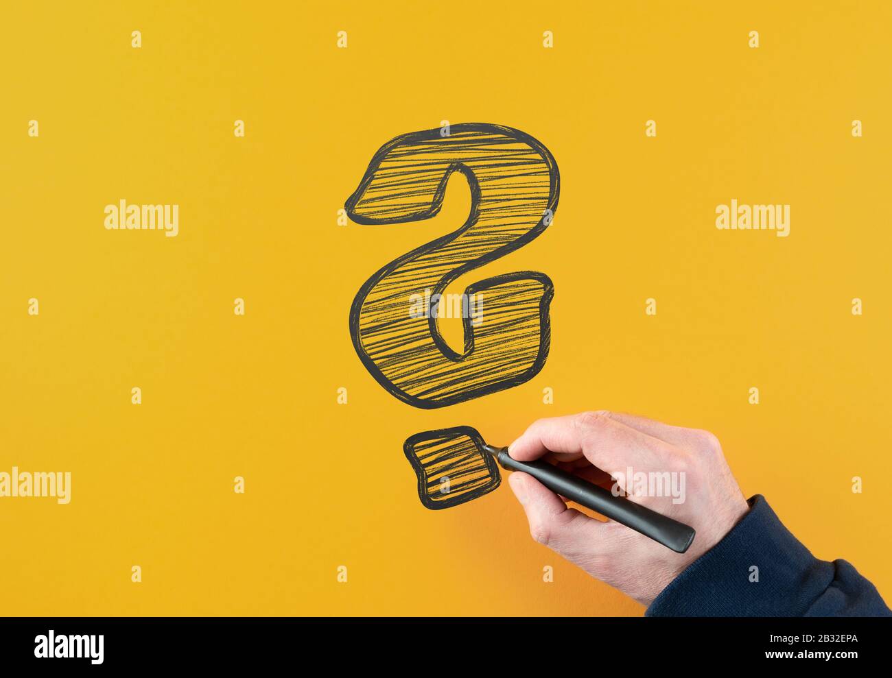 top view of man holding felt tip pen drawing large question mark on ...