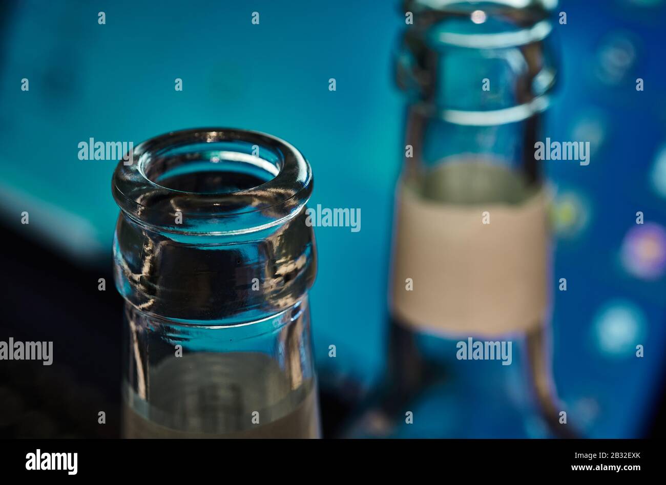 Empty beer bottles, upper part, in front of a switched on Momitor ...