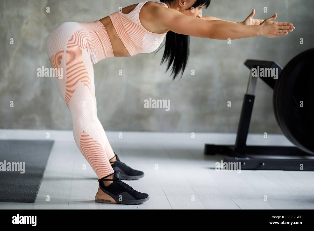 Young pretty woman, middle-aged, well-built physique, warms up before ...