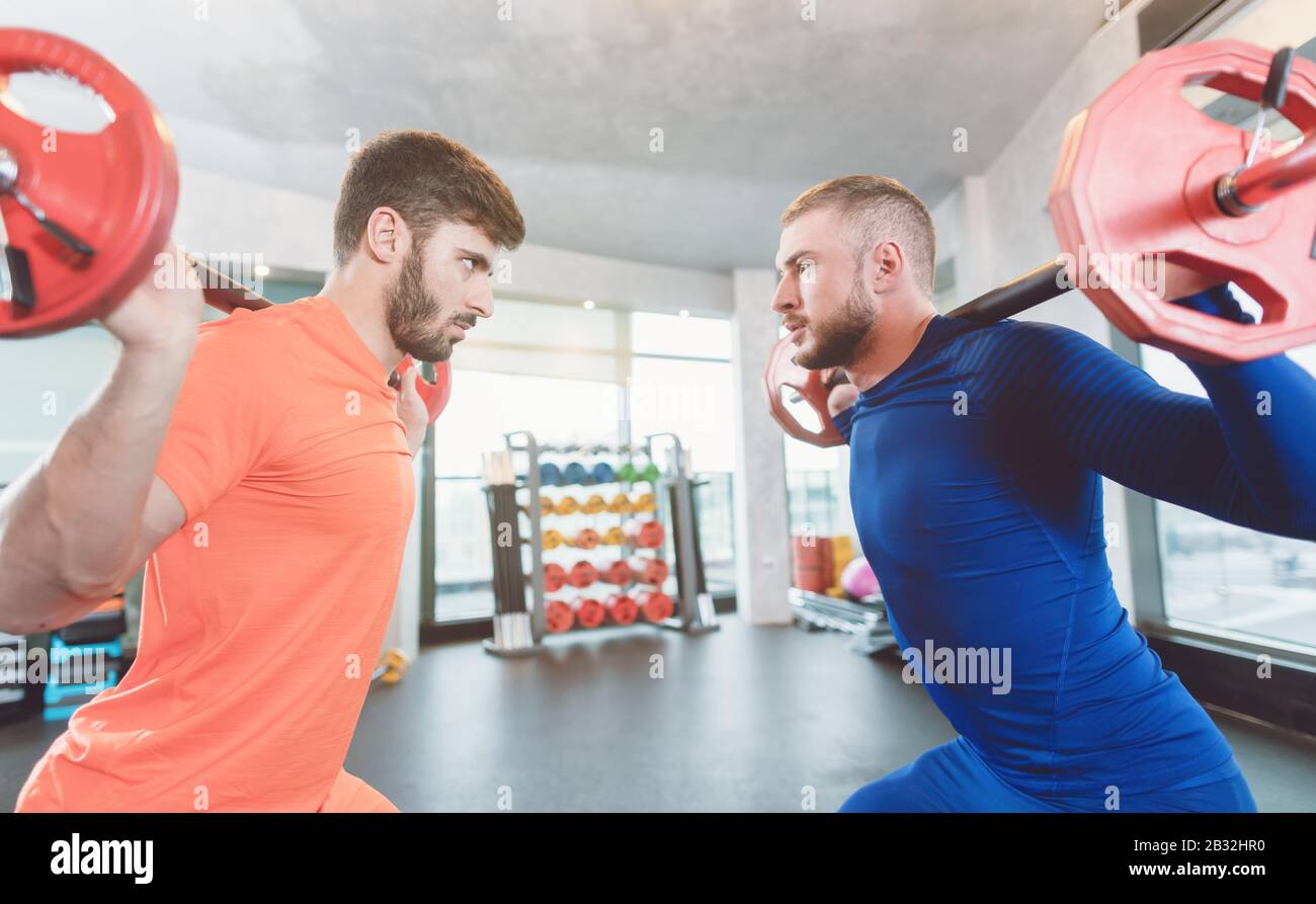 Two competitive young man lifting weights in the gym Stock Photo - Alamy
