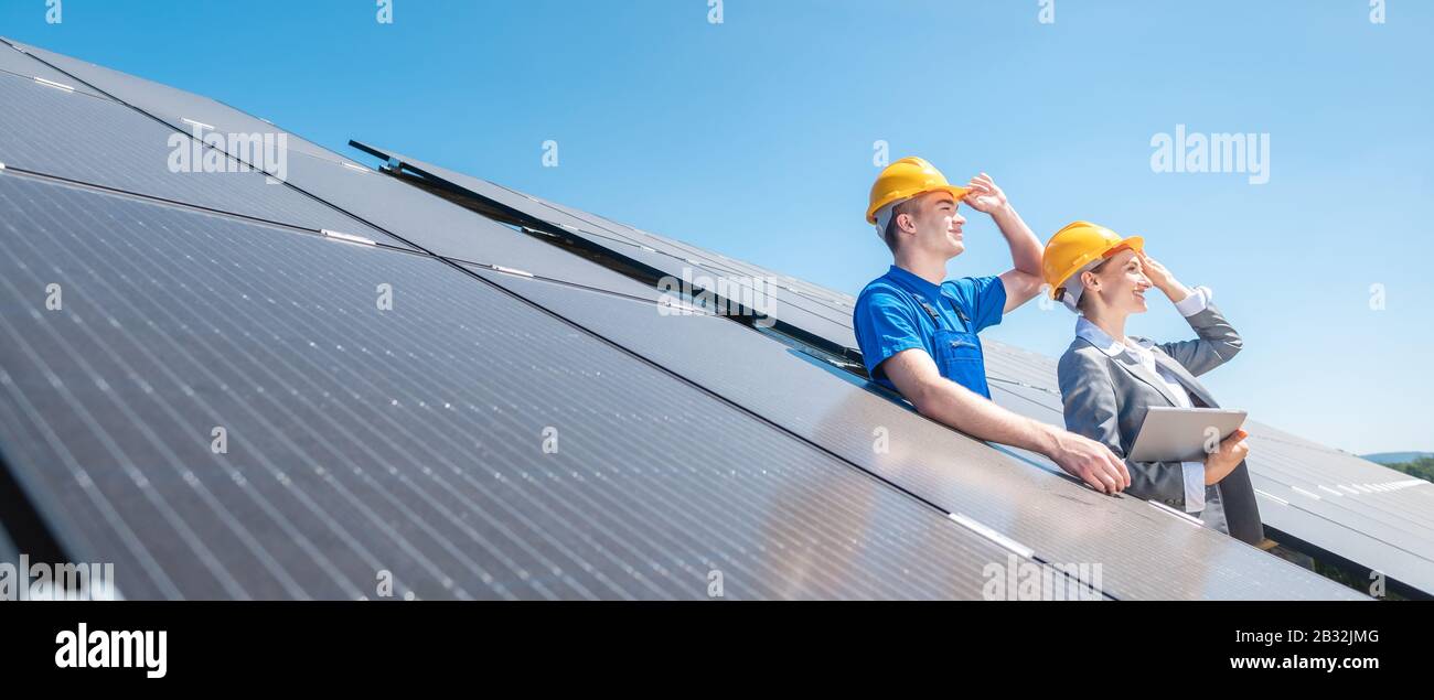 Worker and manager of solar farm looking into the sun Stock Photo - Alamy