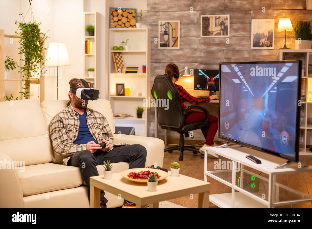 Man gamer using a VR headset to play video games in the living room ...