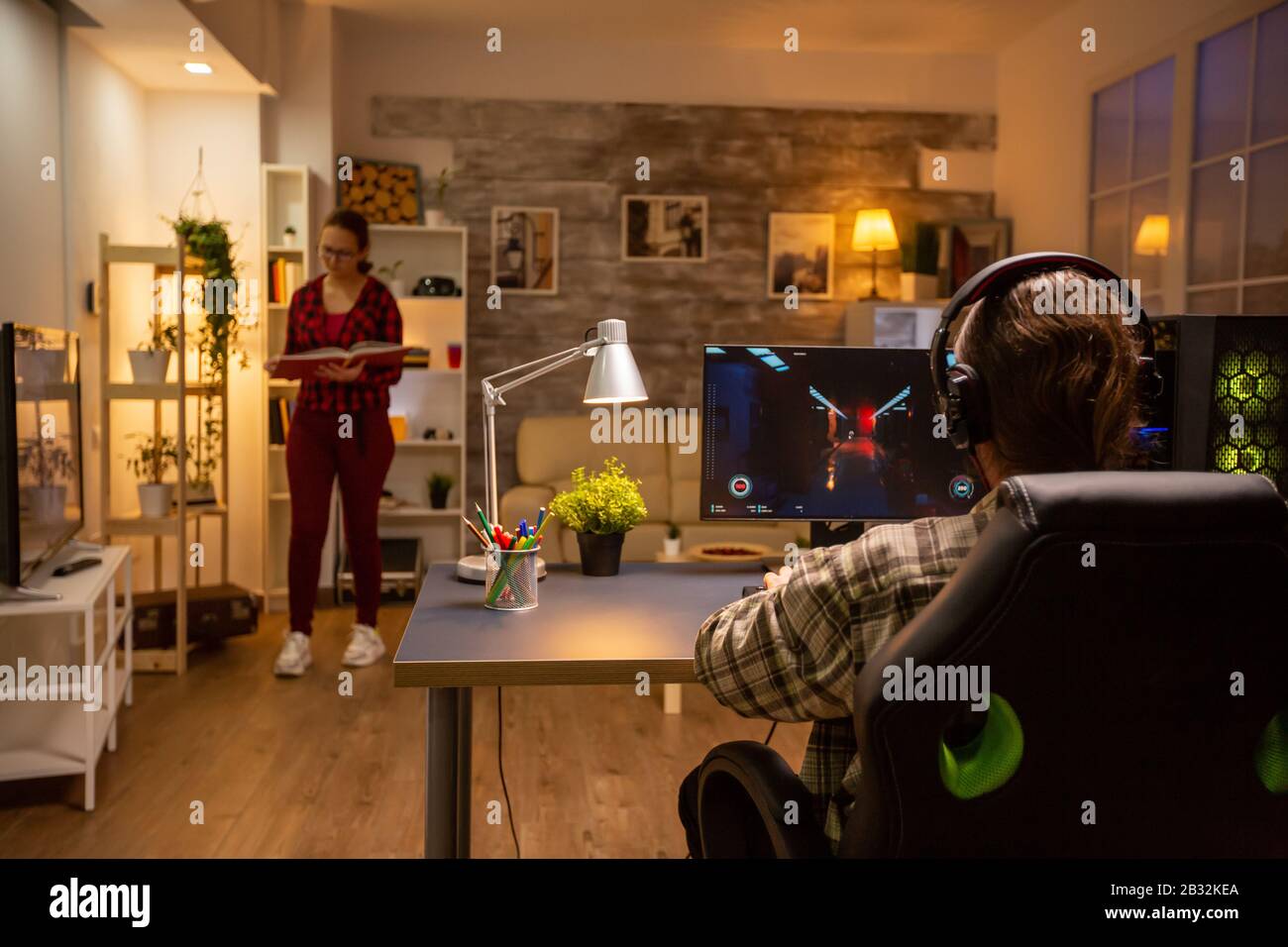 Back view of professional video gamer playing on powerful PC late at ...
