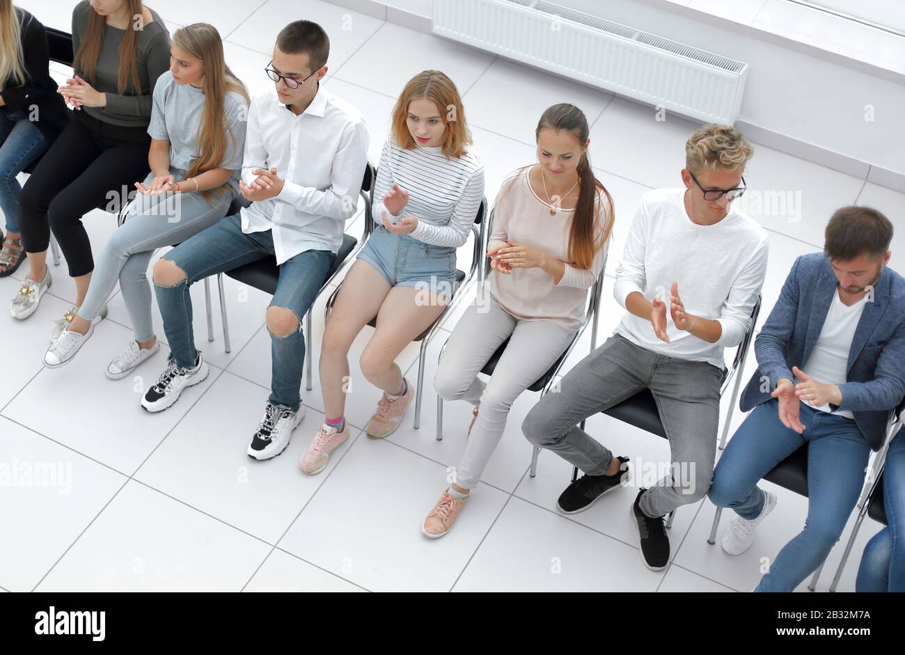 young listeners of business training sitting in one row Stock Photo - Alamy