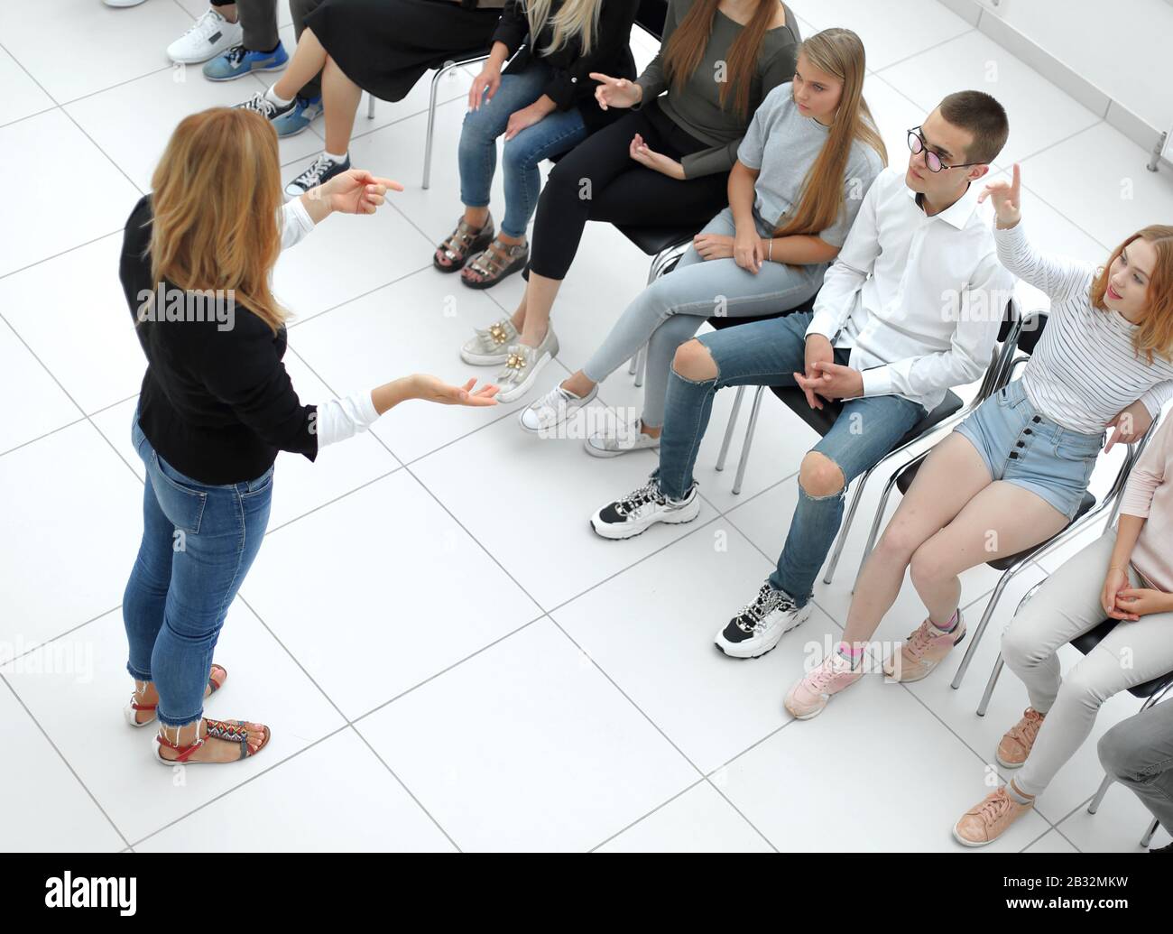 Young Woman Standing In Front Of A Group Of Diverse Young People Stock