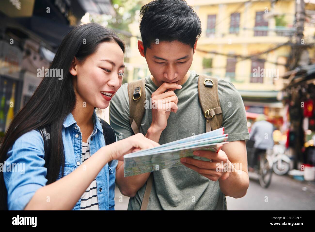 Tourists looking at the directions from map Stock Photo - Alamy