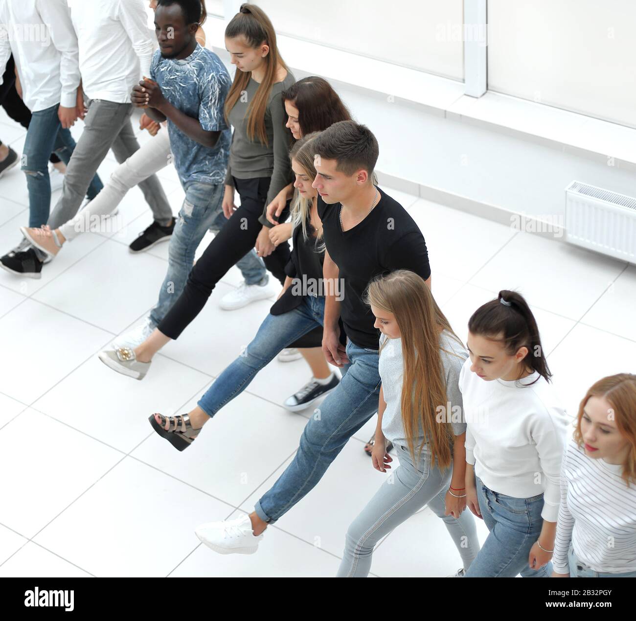 diverse young people standing in a row and pointing to a copy of the ...