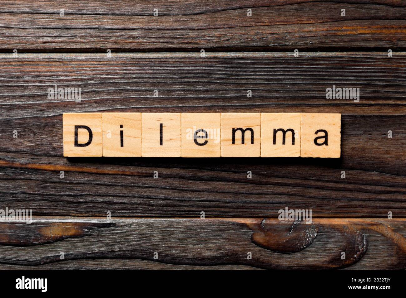 Dilemma word written on wood block. Dilemma text on wooden table for ...