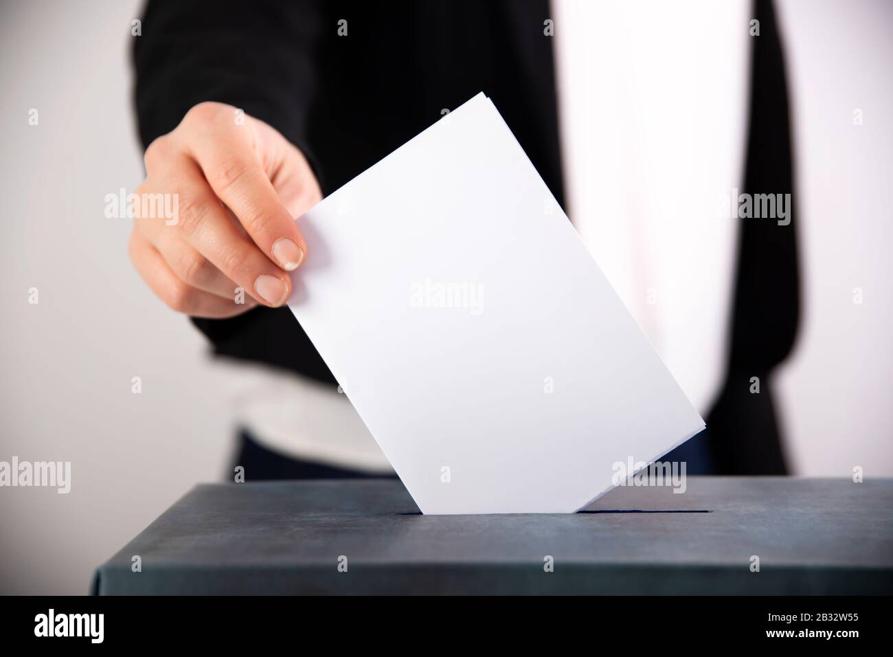 Hand of a voter putting vote in the ballot box. Election concept Stock ...