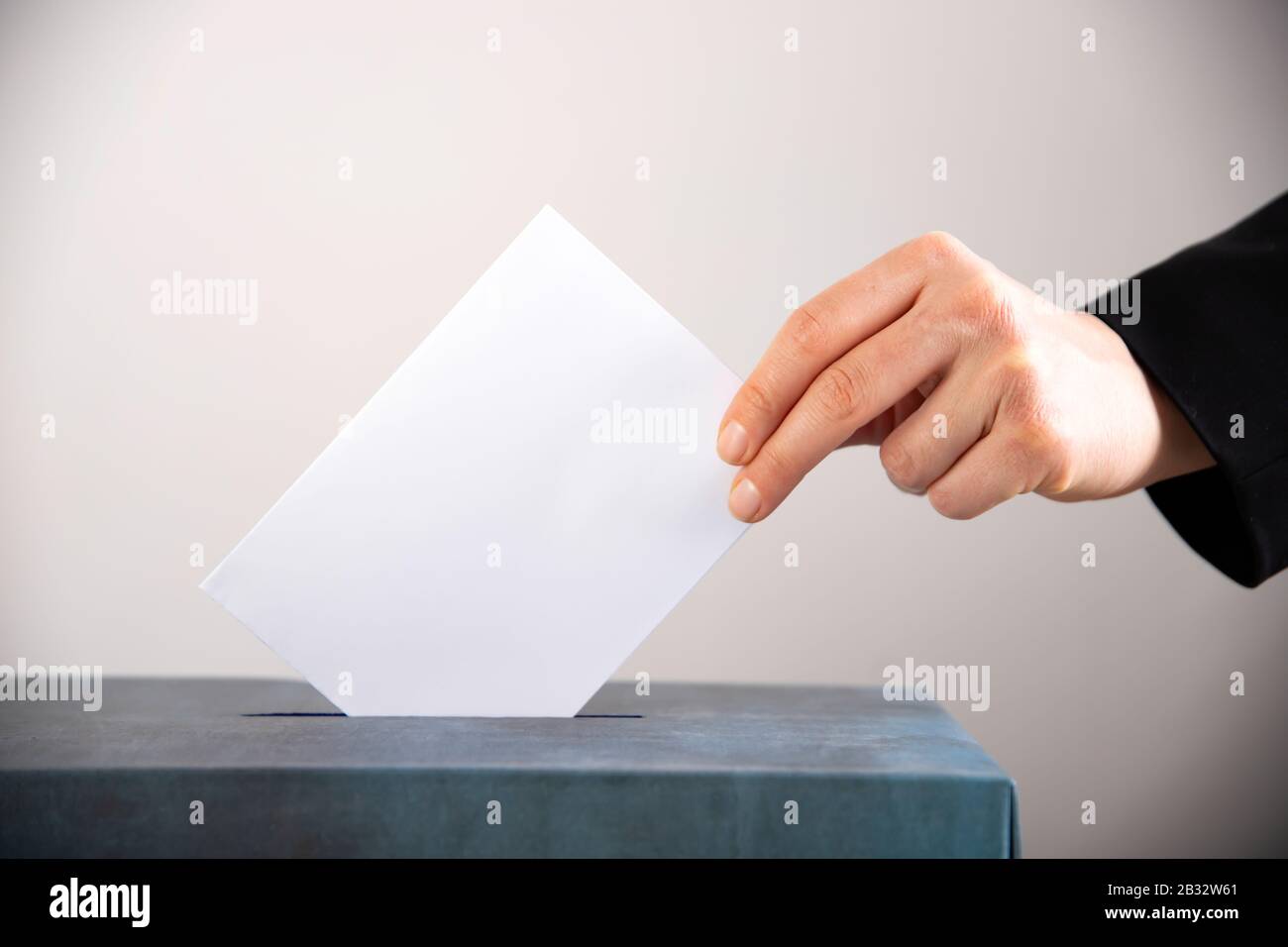 Hand of a voter putting vote in the ballot box. Election concept Stock ...