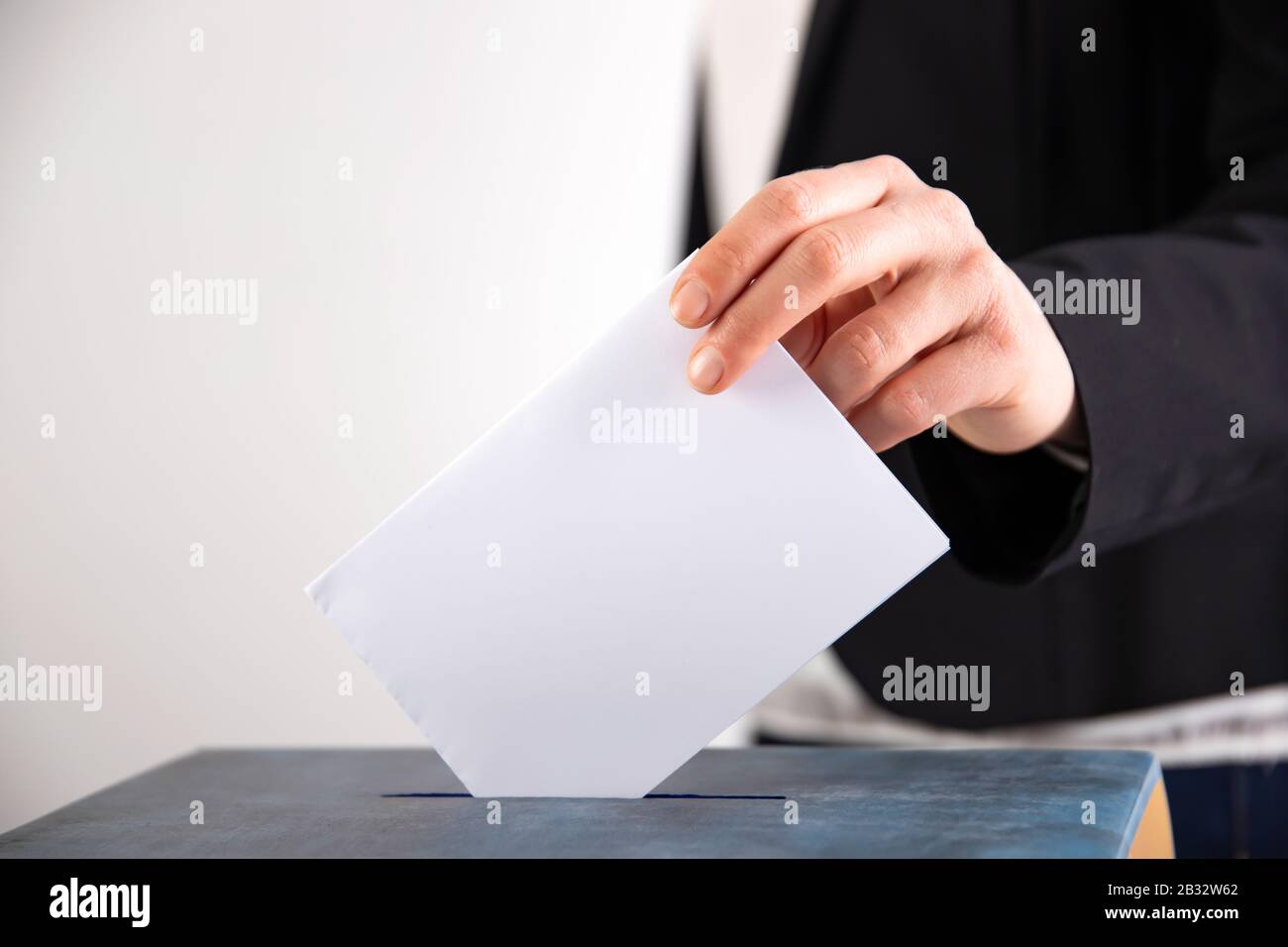 Hand of a voter putting vote in the ballot box. Election concept Stock ...