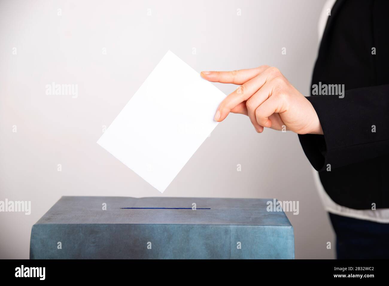 Hand of a voter putting vote in the ballot box. Election concept Stock ...