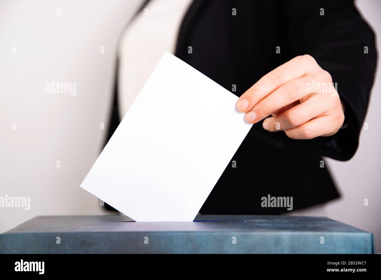 Hand of a voter putting vote in the ballot box. Election concept Stock ...