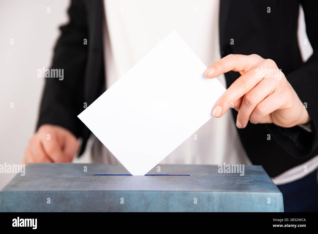 Hand of a voter putting vote in the ballot box. Election concept Stock ...