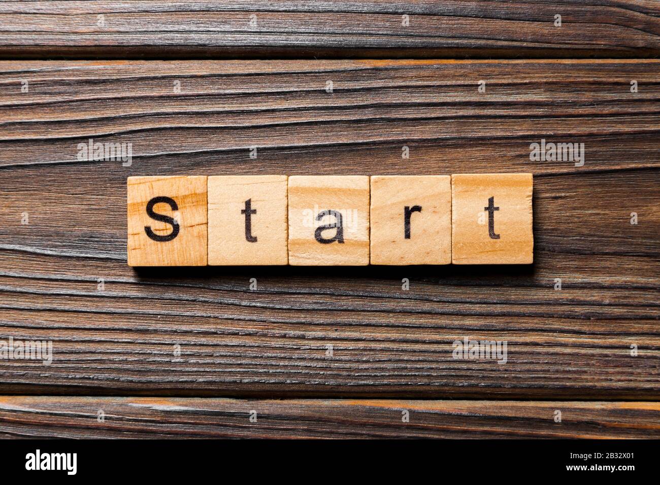 Start word written on wood block. Start text on wooden table for your ...