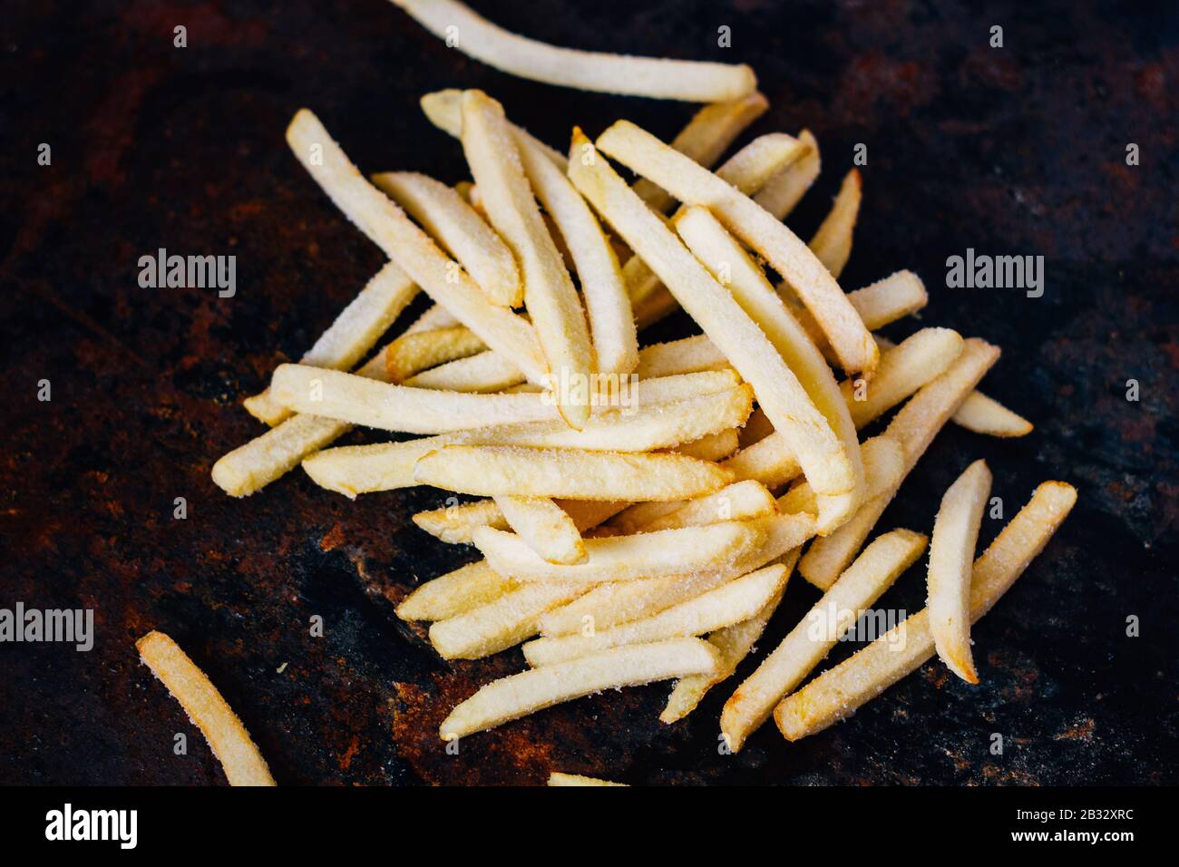 Lot of frozen potatoes fry on black rust background Stock Photo - Alamy