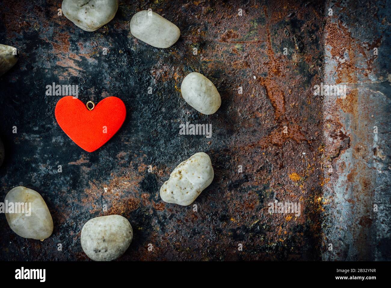 Red heart in circle of rocks on black background Stock Photo - Alamy