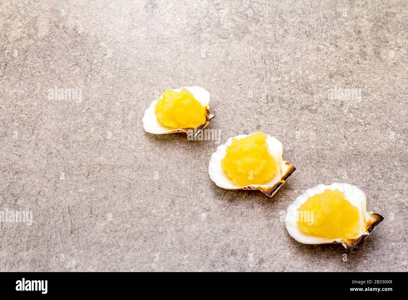 Capelin roe in seashells. Lightly salted caviar snack on a stone ...