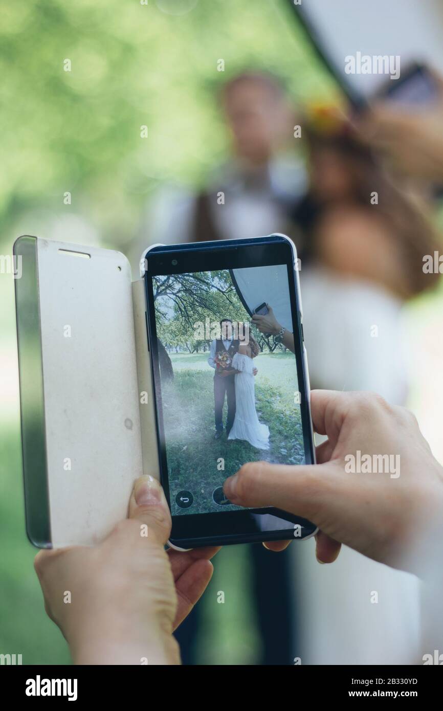 Photographing a wedding couple by the smartphone Stock Photo - Alamy