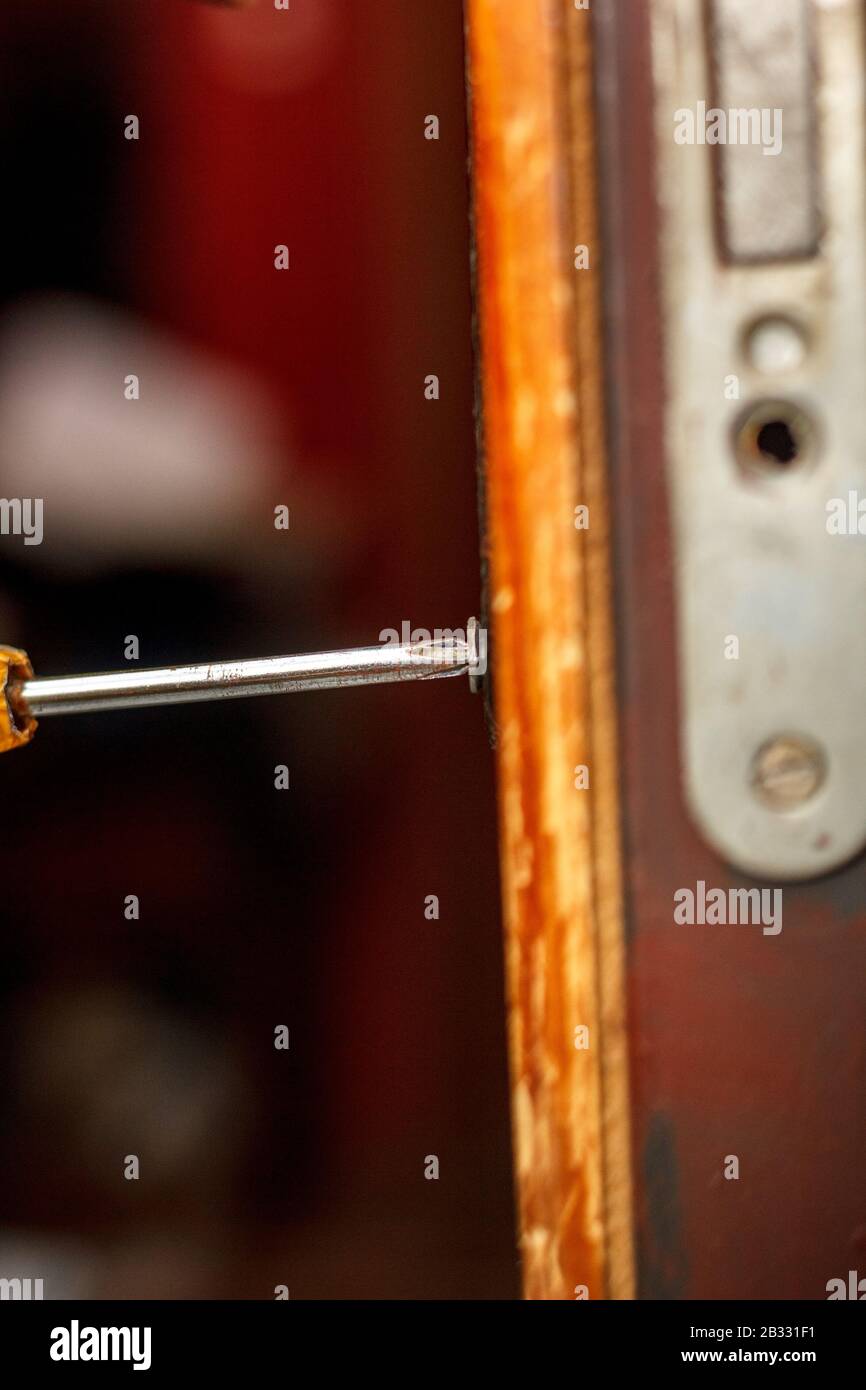 Locksmith making installation of door lock with screwdriver Stock Photo ...