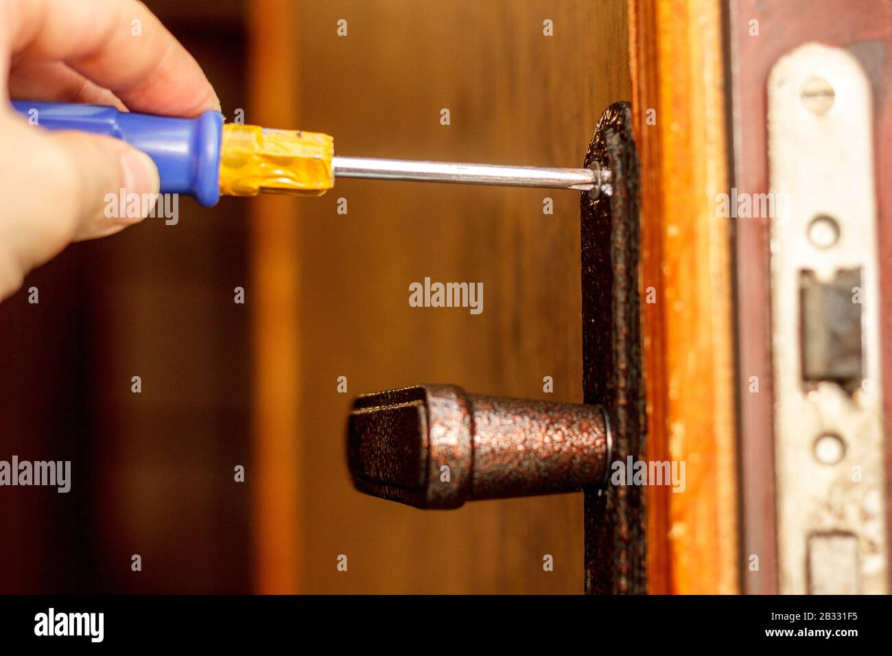 Locksmith making installation of door lock with screwdriver Stock Photo ...