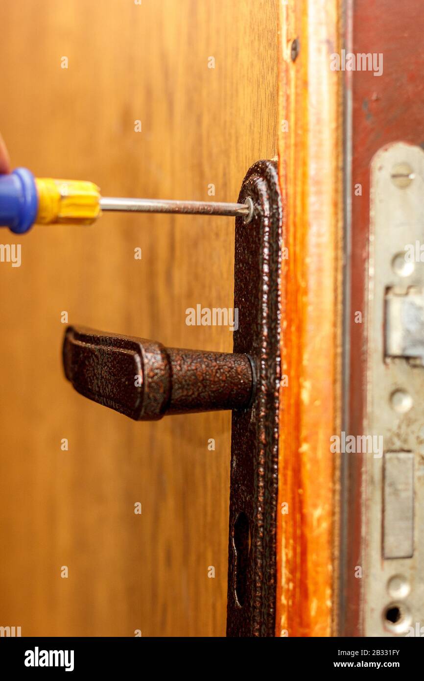 Locksmith making installation of door lock with screwdriver Stock Photo ...