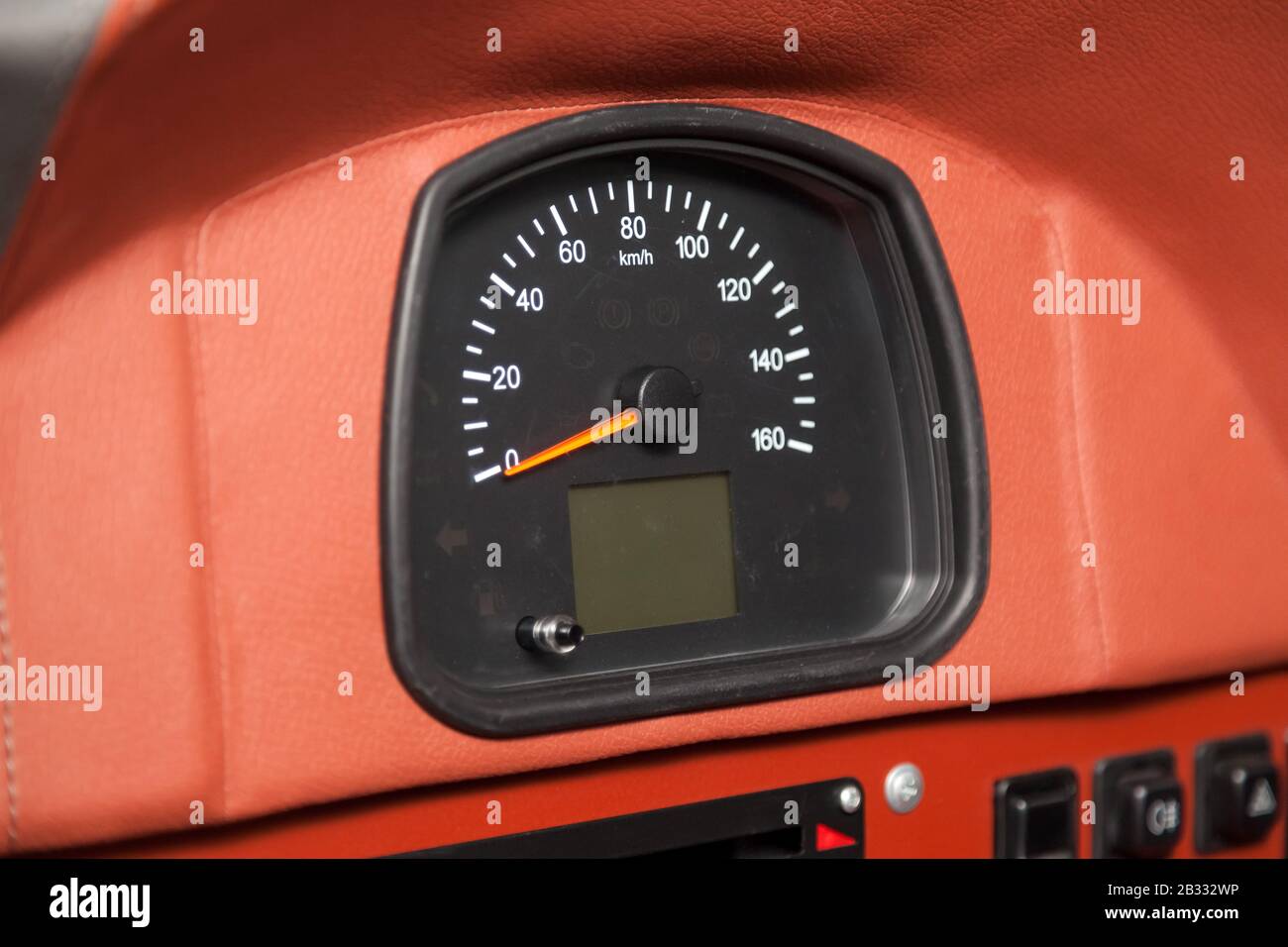 Simple analog car speedometer with a red arrow on a leather trimmed ...