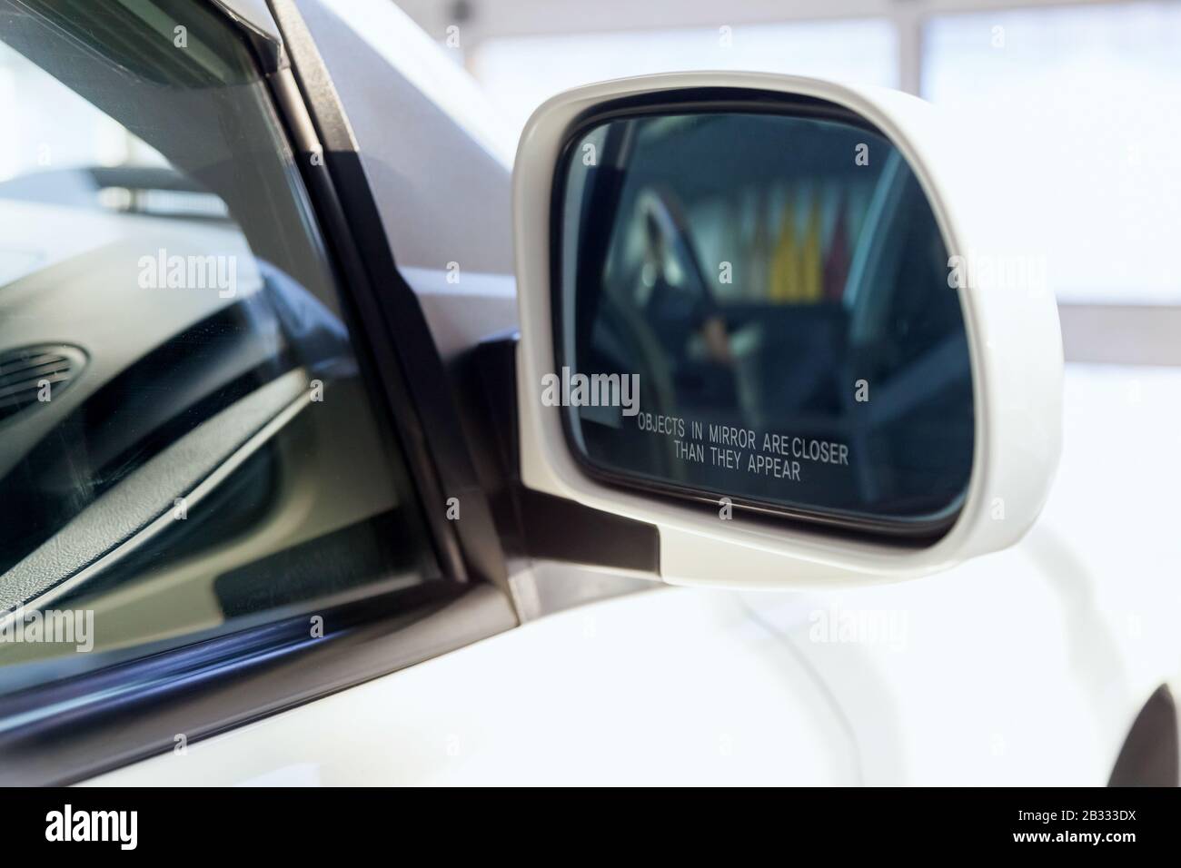 Side rear-view mirror with an inscription warning that objects are ...