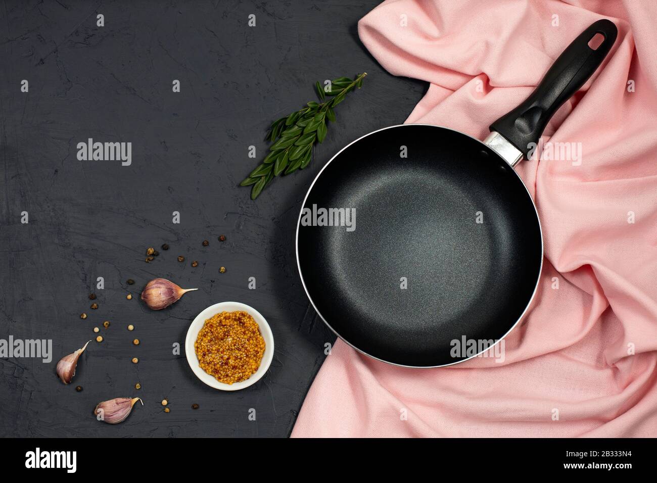 Food cooking background with black frying pan or skillet, spices and ...