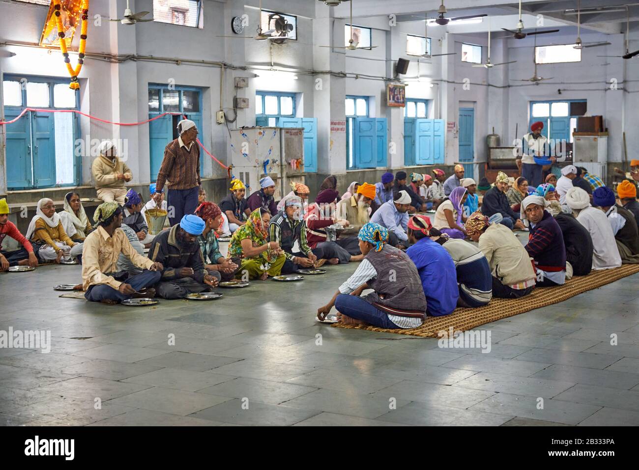 men eating in community kitchen in Shish Ganj Gurudwara Sikh Temple in ...