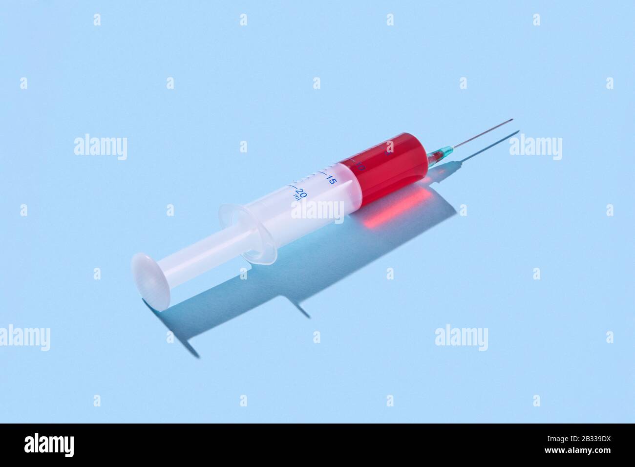 Disposable syringe of red vaccine with hard shadow Stock Photo - Alamy