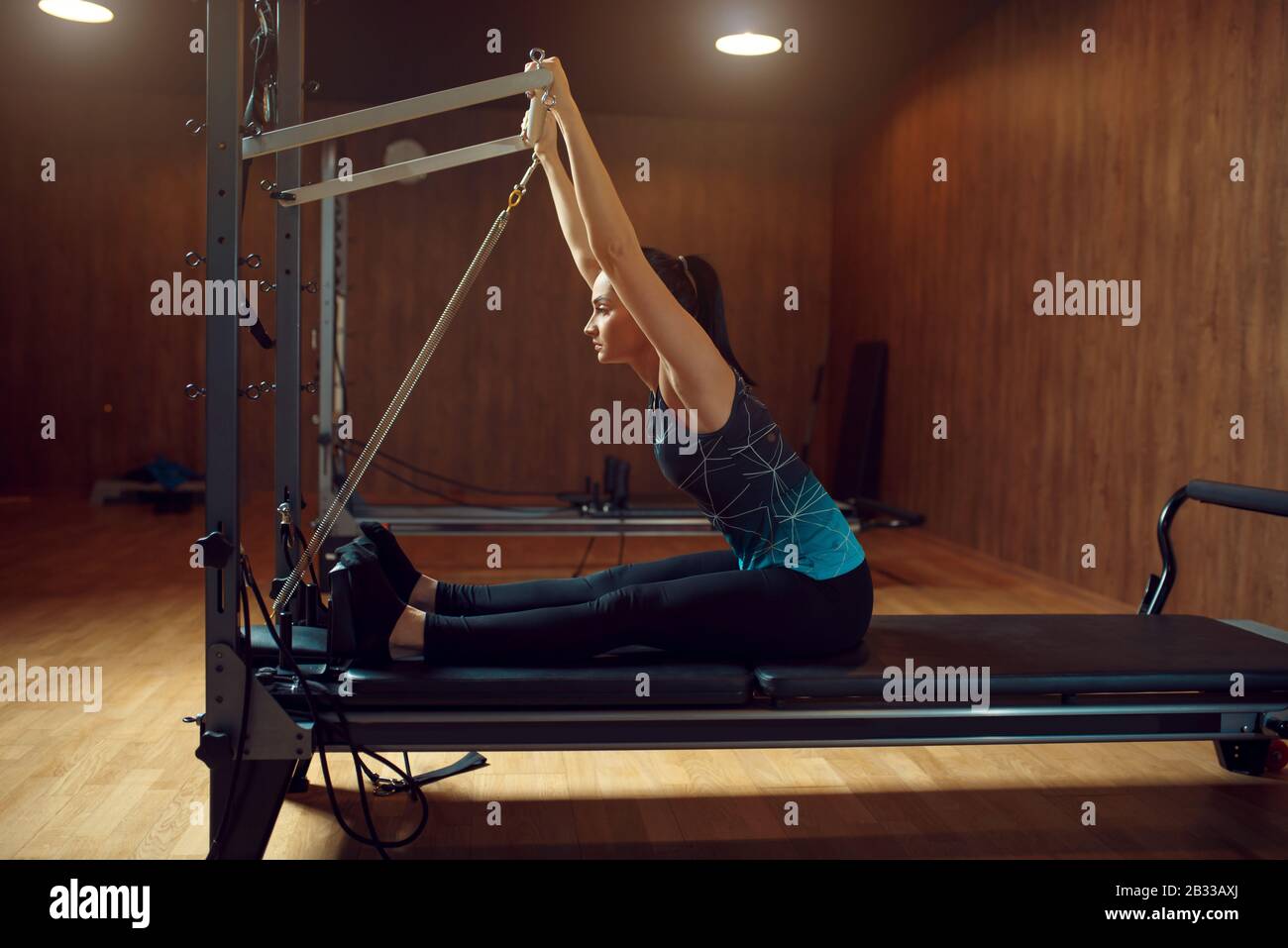 Woman doing stretching pilates exercise in gym Stock Photo - Alamy
