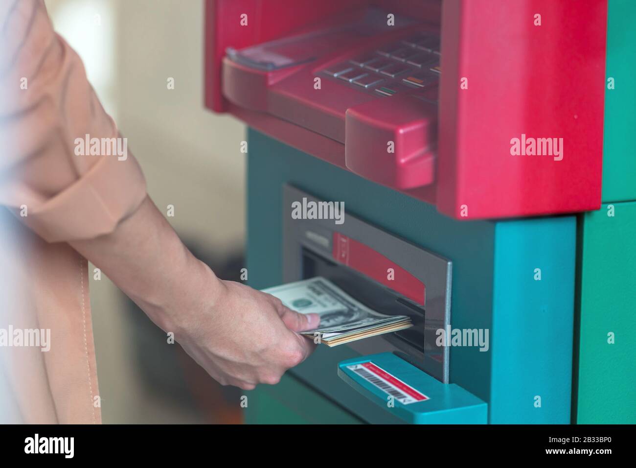 Closeup woman holding the wallet and withdrawing the cash via ATM ...