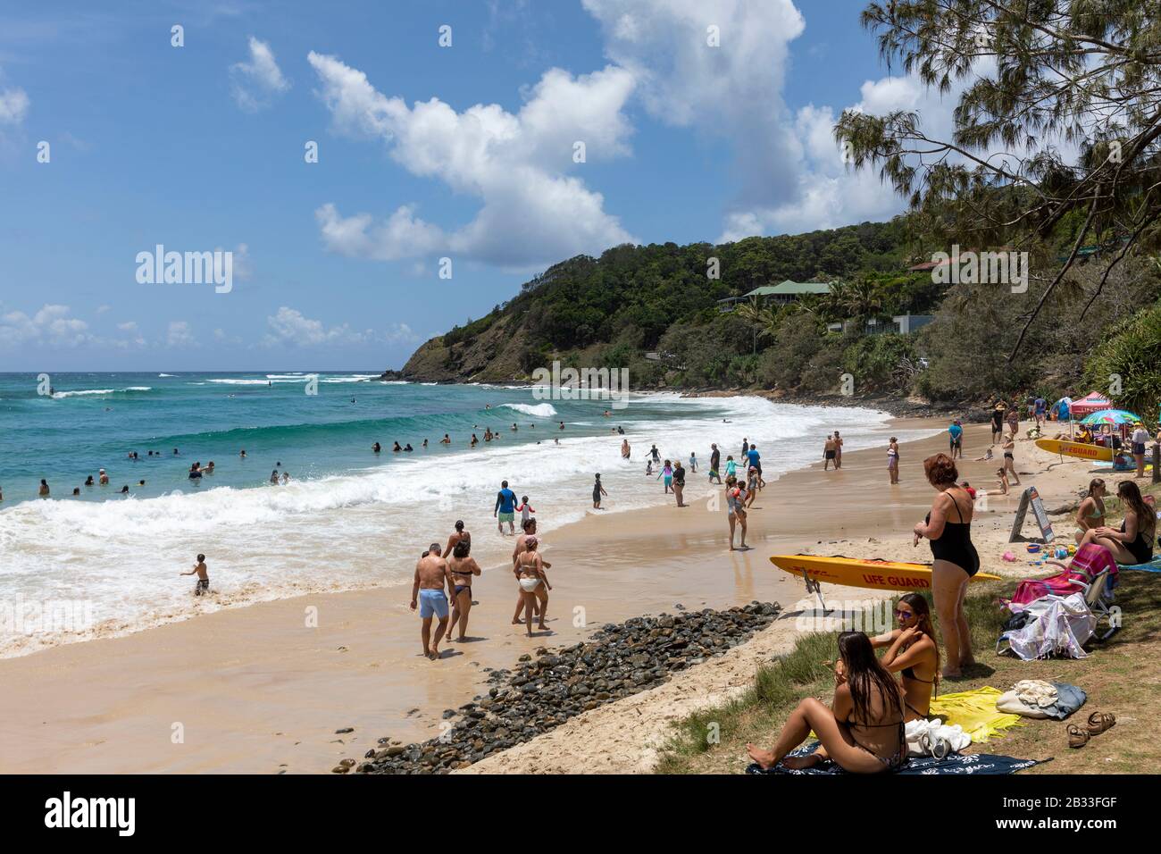 Byron Bay summer people relaxing and swimming on waters beach in Byron ...