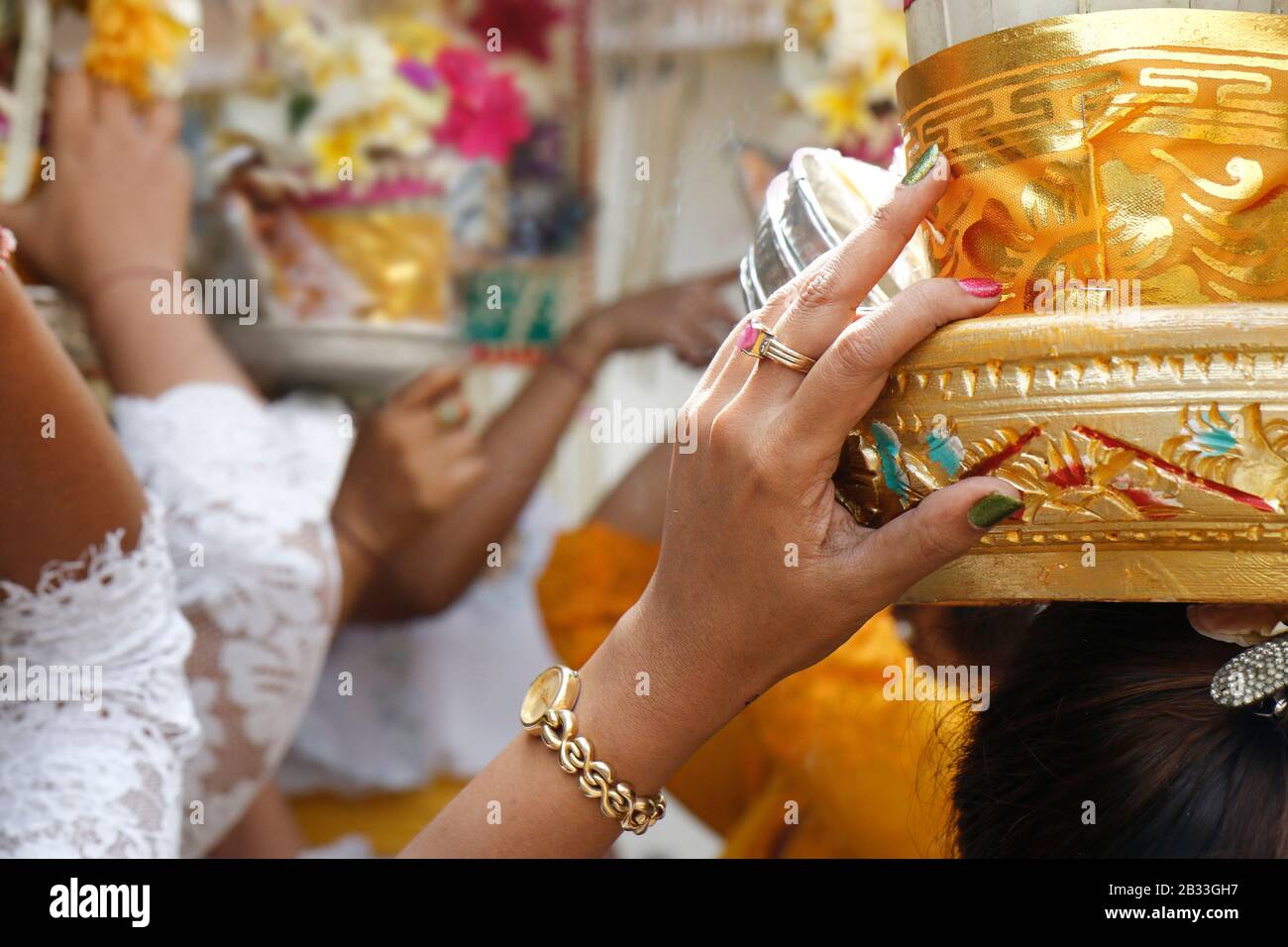 Balinese woman holding offering on the head during ceremony in Bali ...