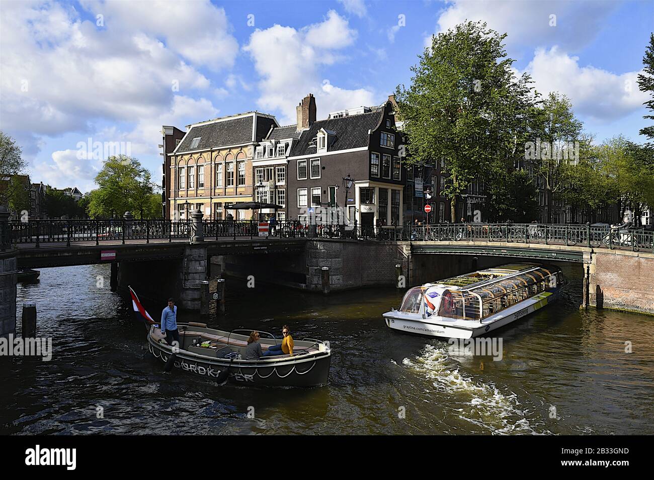 Tourboat passing under bridge Amsterdam Netherlands Stock Photo - Alamy