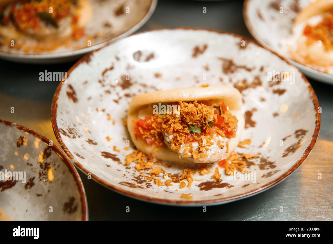 Steamed kebab with rotan in a bun. The dish lies in a round plate ...