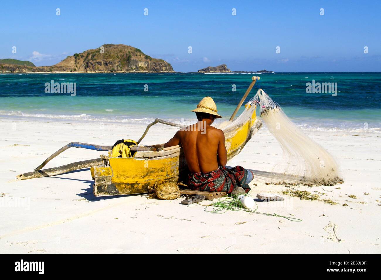 FISHERMAN REPAIRING HIS NET ON A THE WHITE SAND BEACH Stock Photo - Alamy