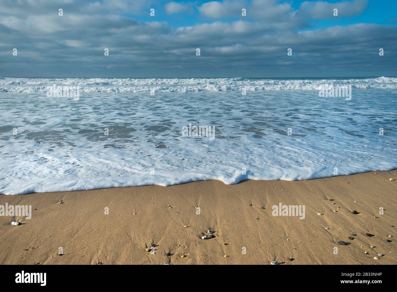 An incoming wave gently flowing on the Beach at Fistral in Newquay in ...