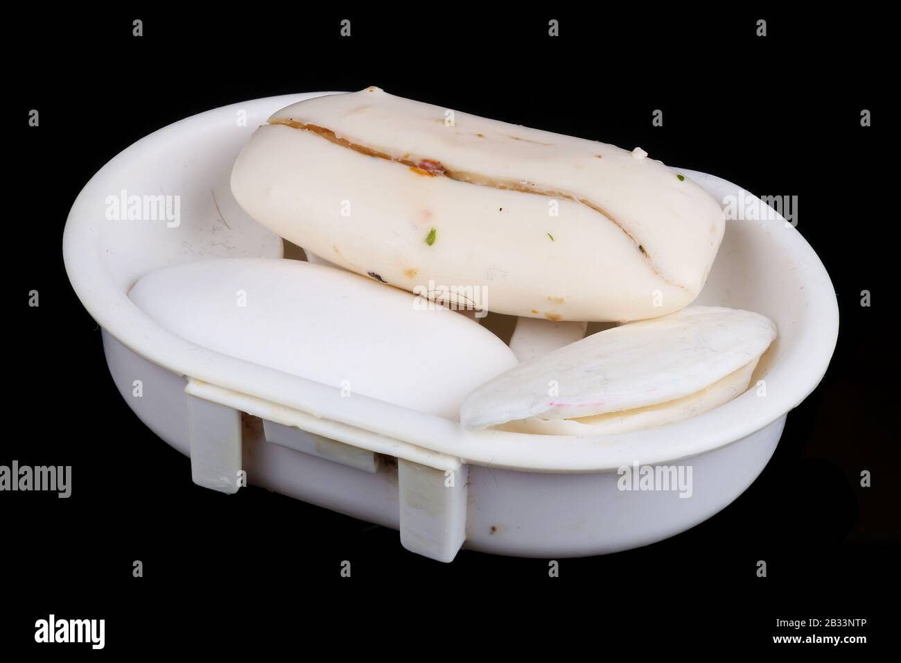 Old rustic dry cracked white soaps slices in plastic broken dishe ...