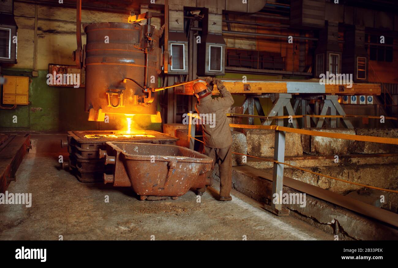 Steelmaker pours liquid metal from basket, factory Stock Photo - Alamy