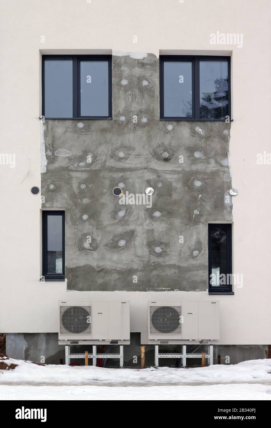 Snow and frozen no name conditioners. Concrete wall of the rural ...