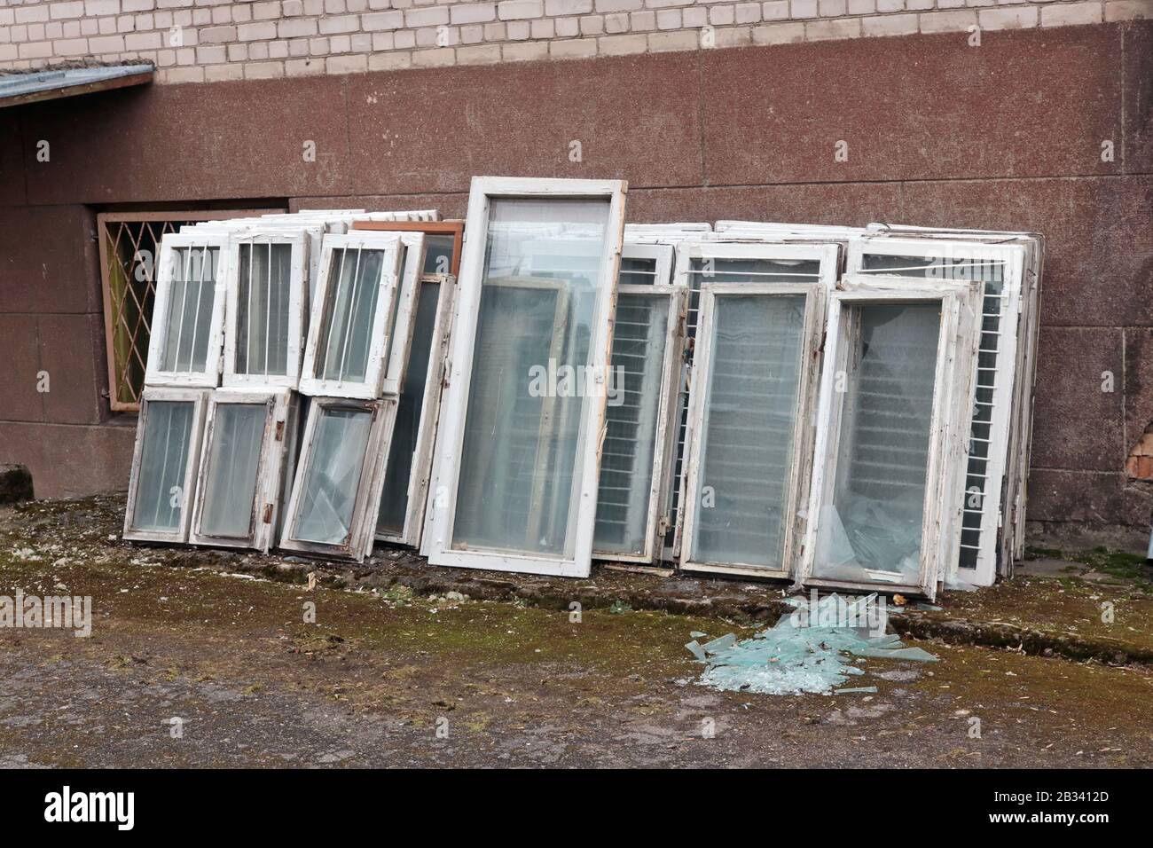 Old broken white wooden windows are withdrawn from the building for ...