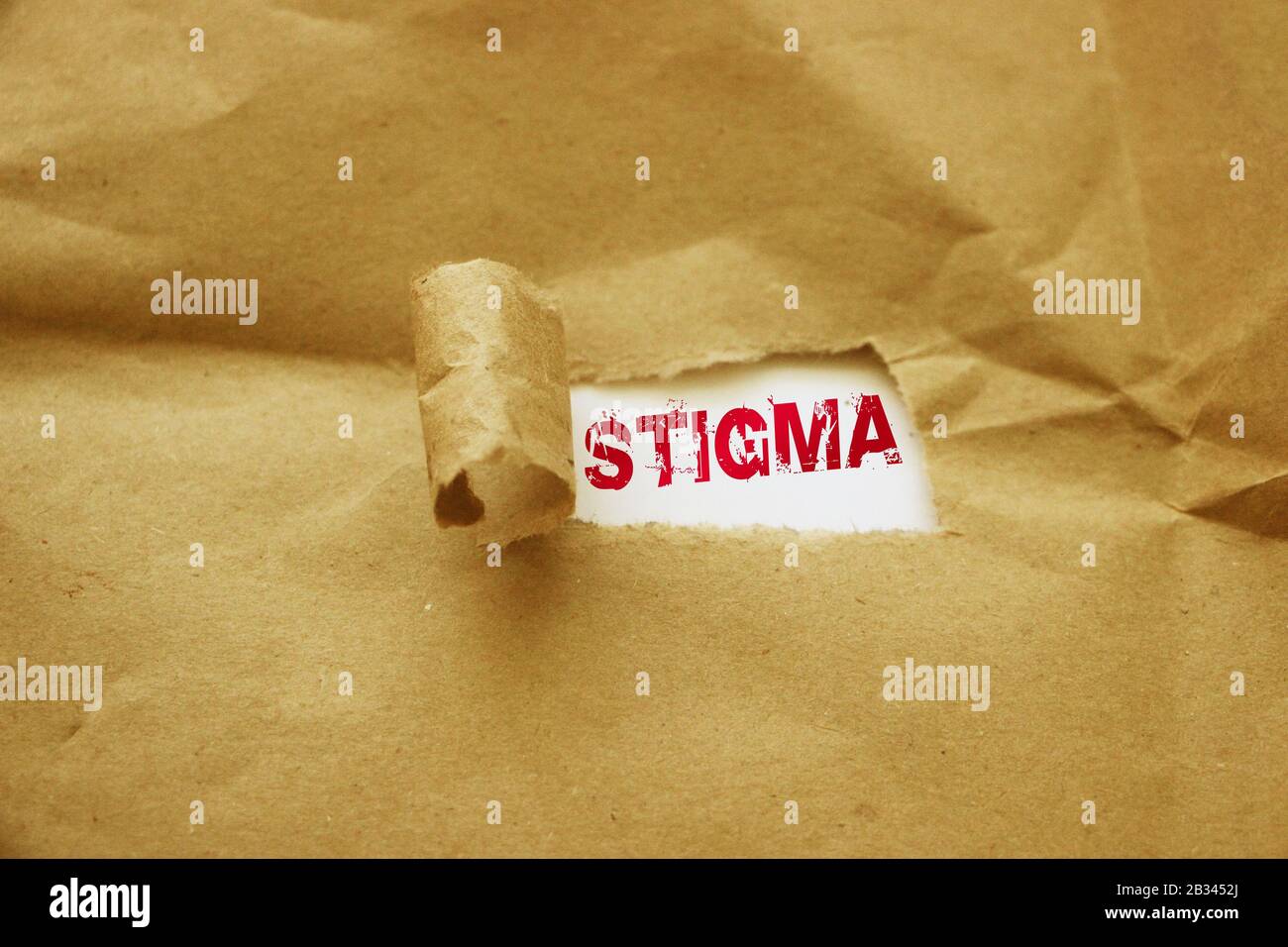 Word Stigma in red letters message written under torn brown package ...