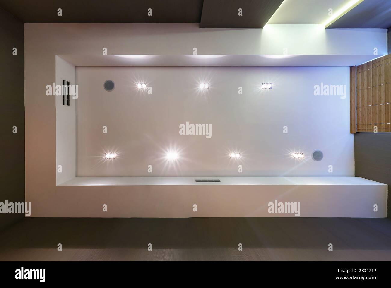 looking up on suspended ceiling with halogen spots lamps and drywall ...