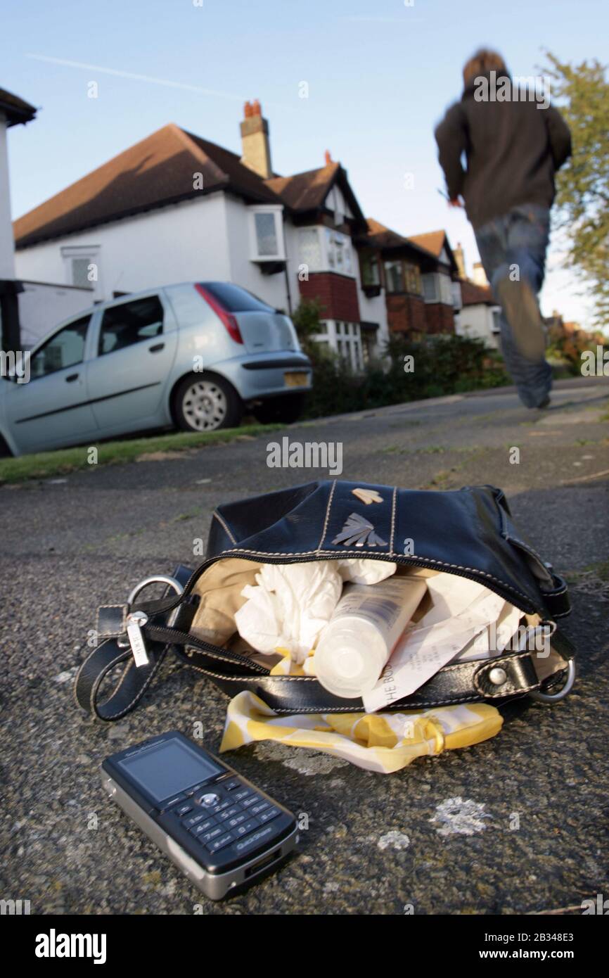 Mugging or attempted mobile phone theft UK. Posed by model Stock Photo ...